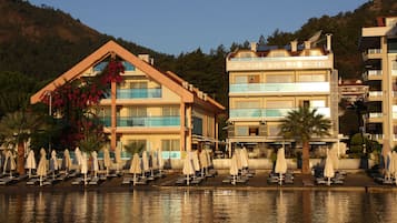 Uma praia privada, espreguiçadeiras, guarda-sóis de praia