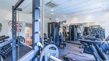 Uma academia com equipamentos de musculação, esteiras e aparelhos de exercício.