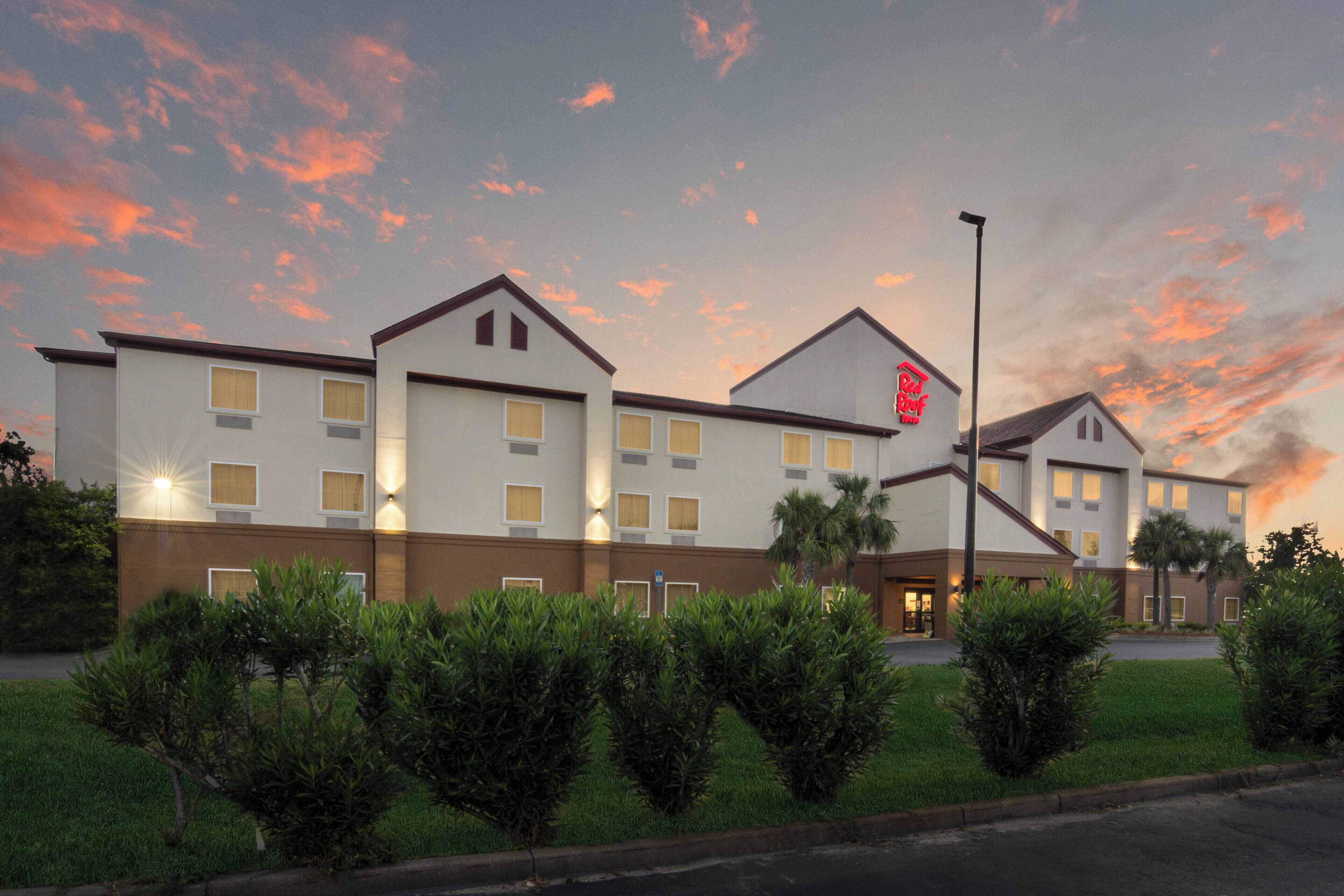 Um hotel com telhado plano, várias janelas e placa da Red Roof Inn.