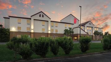 Um hotel com telhado plano, várias janelas e placa da Red Roof Inn.