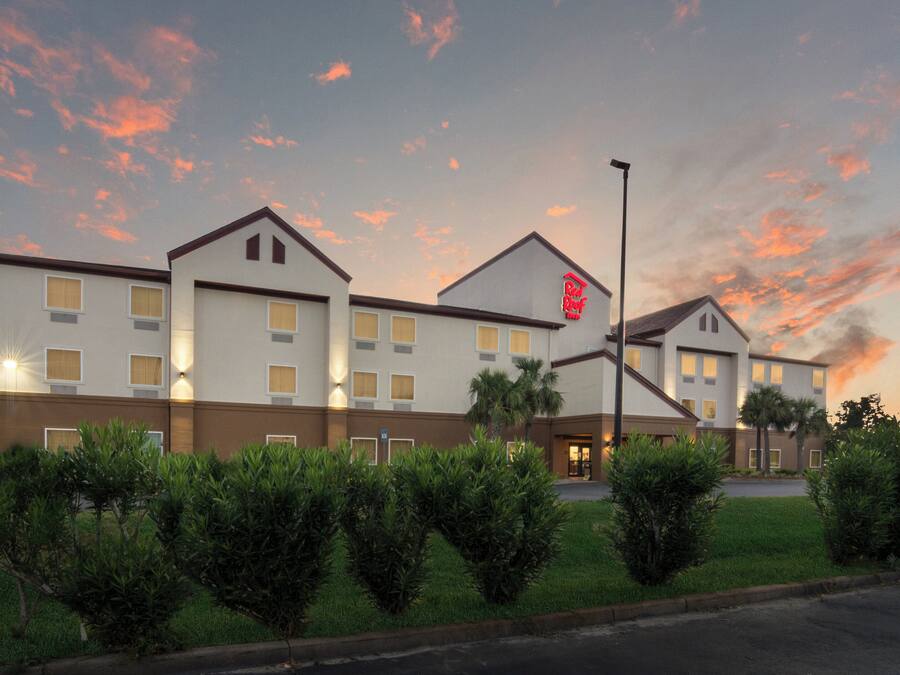 Um hotel com telhado plano, várias janelas e placa da Red Roof Inn.
