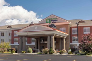 Edifício do Holiday Inn Express & Suites com entrada coberta, vários andares e estacionamento.