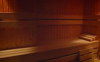 Uma sauna de madeira com bancos e um assento de banco.