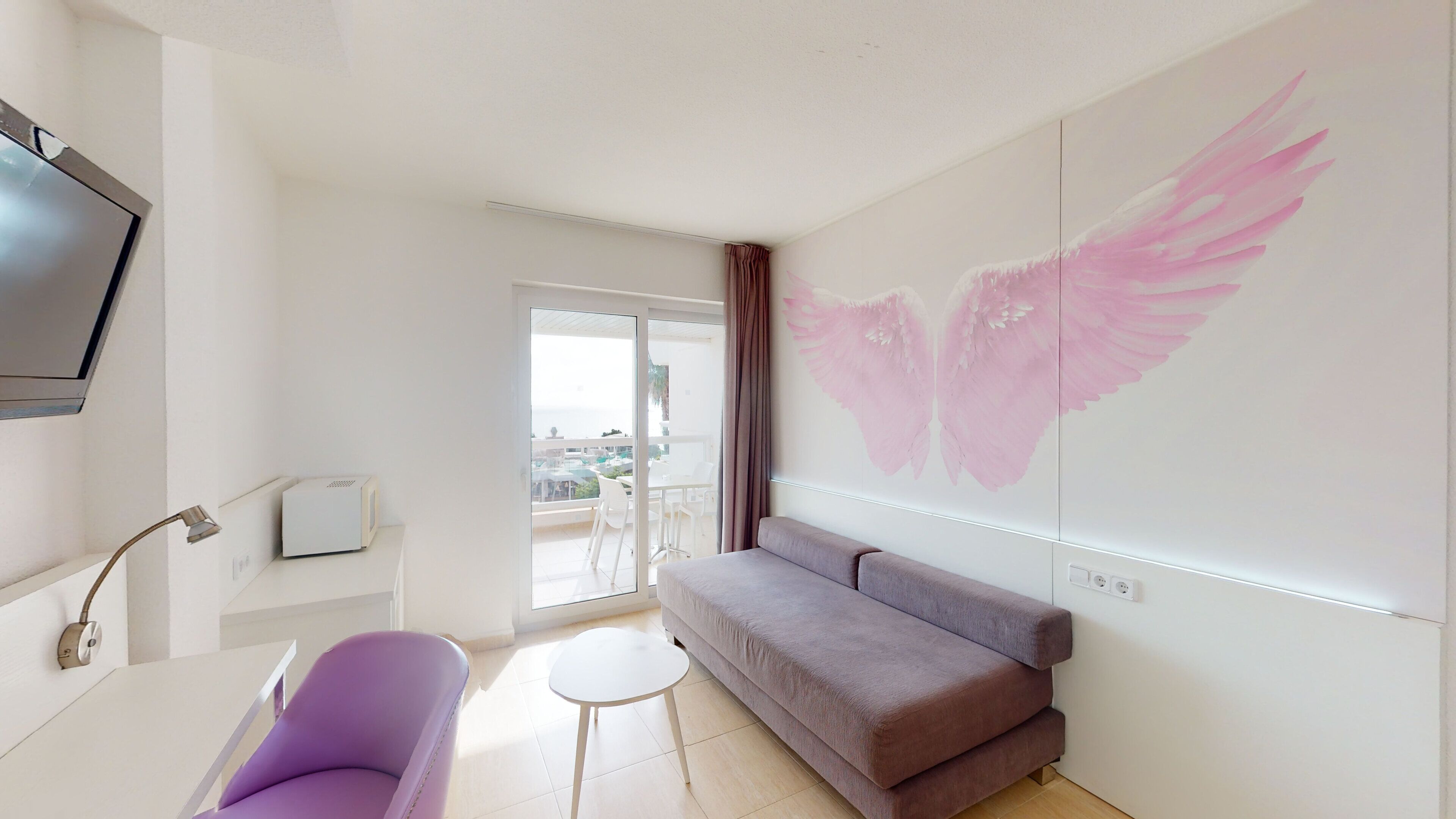 Uma sala de estar moderna com um sofá cinzento, uma poltrona roxa, uma mesa pequena branca e um grande mural rosa em forma de asa na parede.