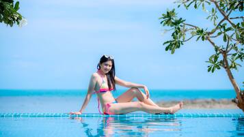 Na praia, areia branca, espreguiçadeiras, guarda-sóis