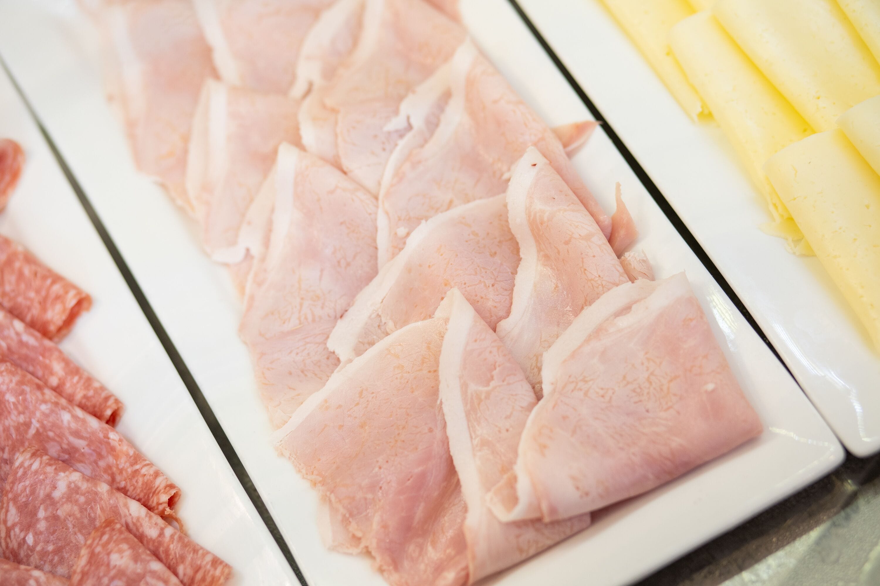 Um prato com carnes fatiadas e legumes.