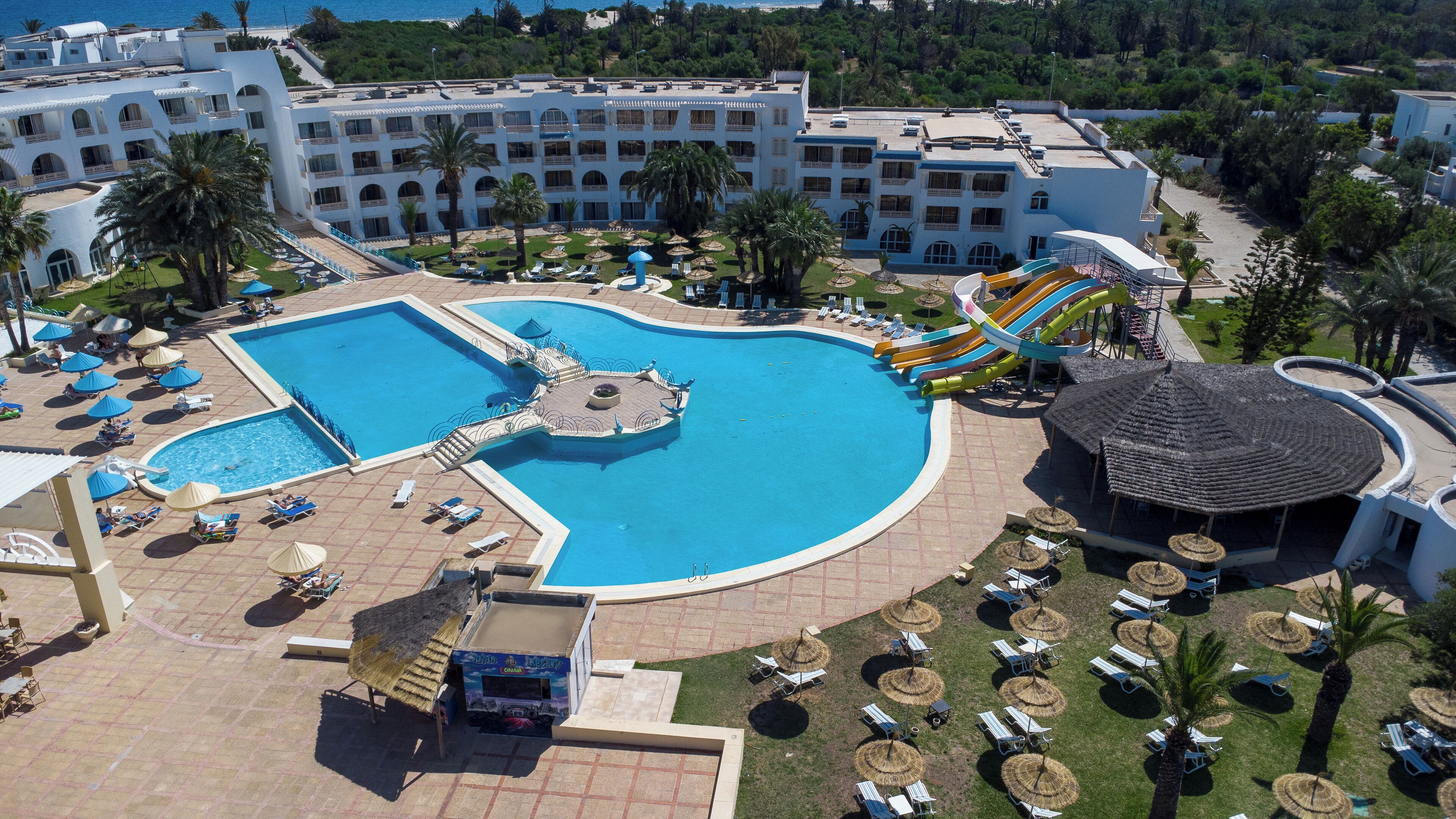 Um resort com várias piscinas, um toboágua e espreguiçadeiras.
