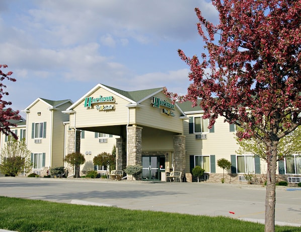 Hotel com fachada de pedra e entrada coberta, exibindo uma placa com o texto "Horizon Inn & Suites".