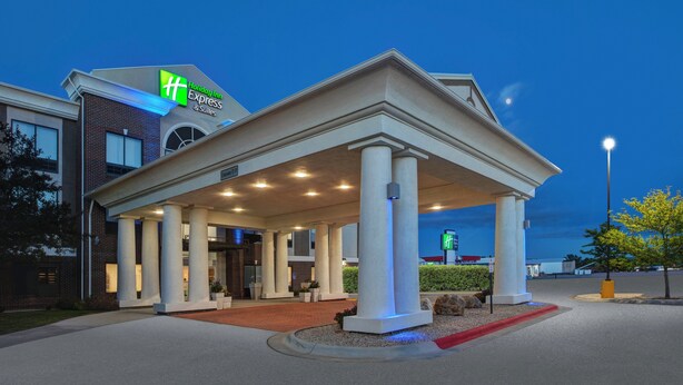 Entrada de hotel com área externa coberta, colunas e placa indicando Fairfield Inn & Suites.