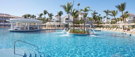 Piscina de resort com água cristalina, palmeiras e espreguiçadeiras.
