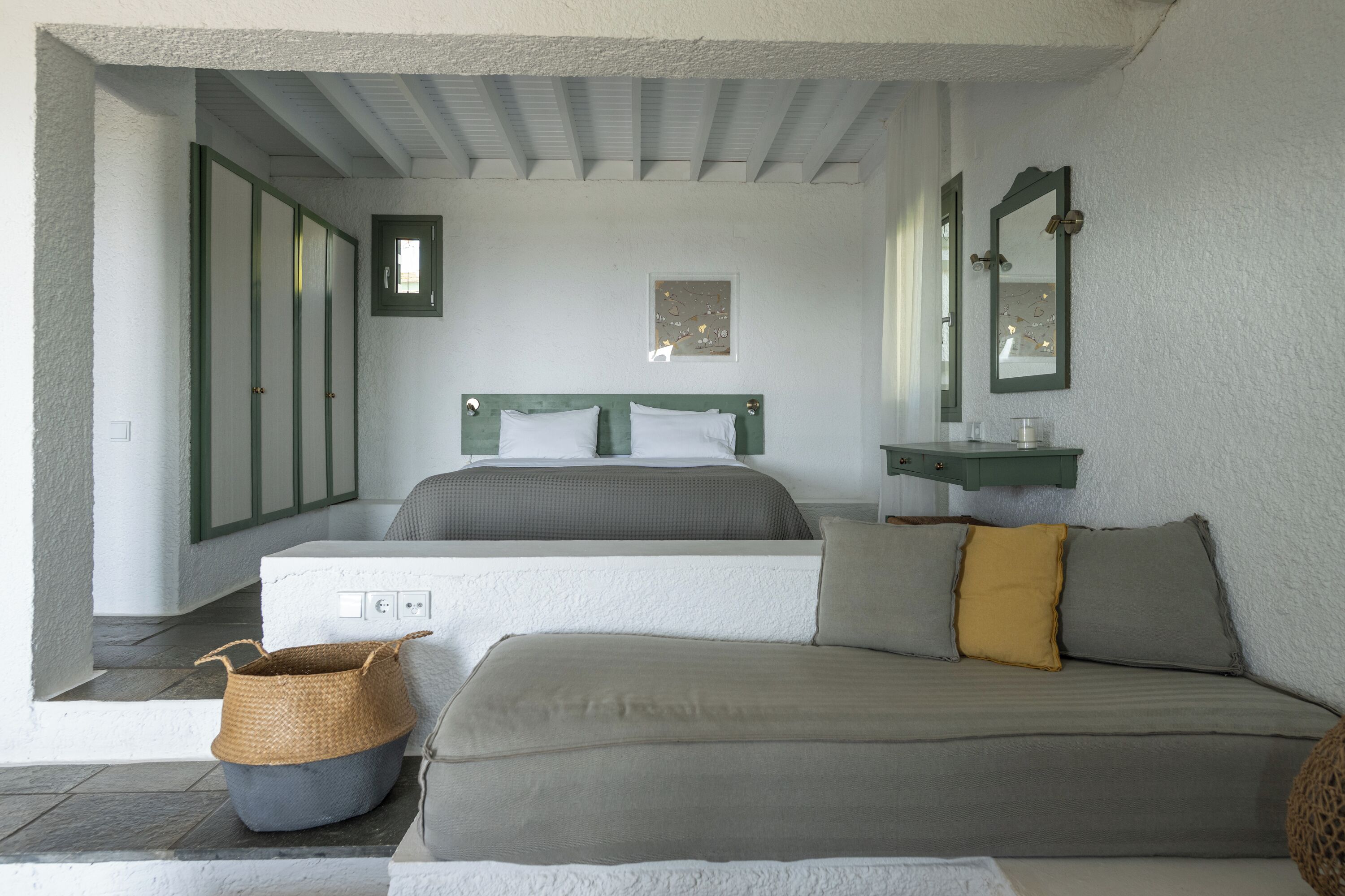 Quarto com cama, mesa de cabeceira e janela.