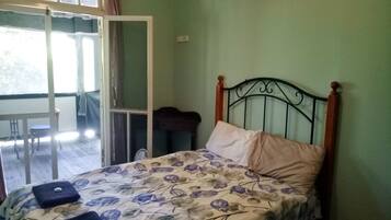 Um quarto com uma cama, uma mesa e uma cadeira.