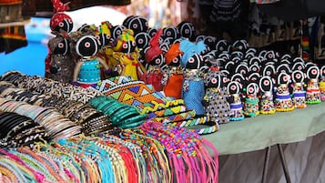 Uma variedade de joias e acessórios coloridos feitos de contas, expostos sobre uma mesa.