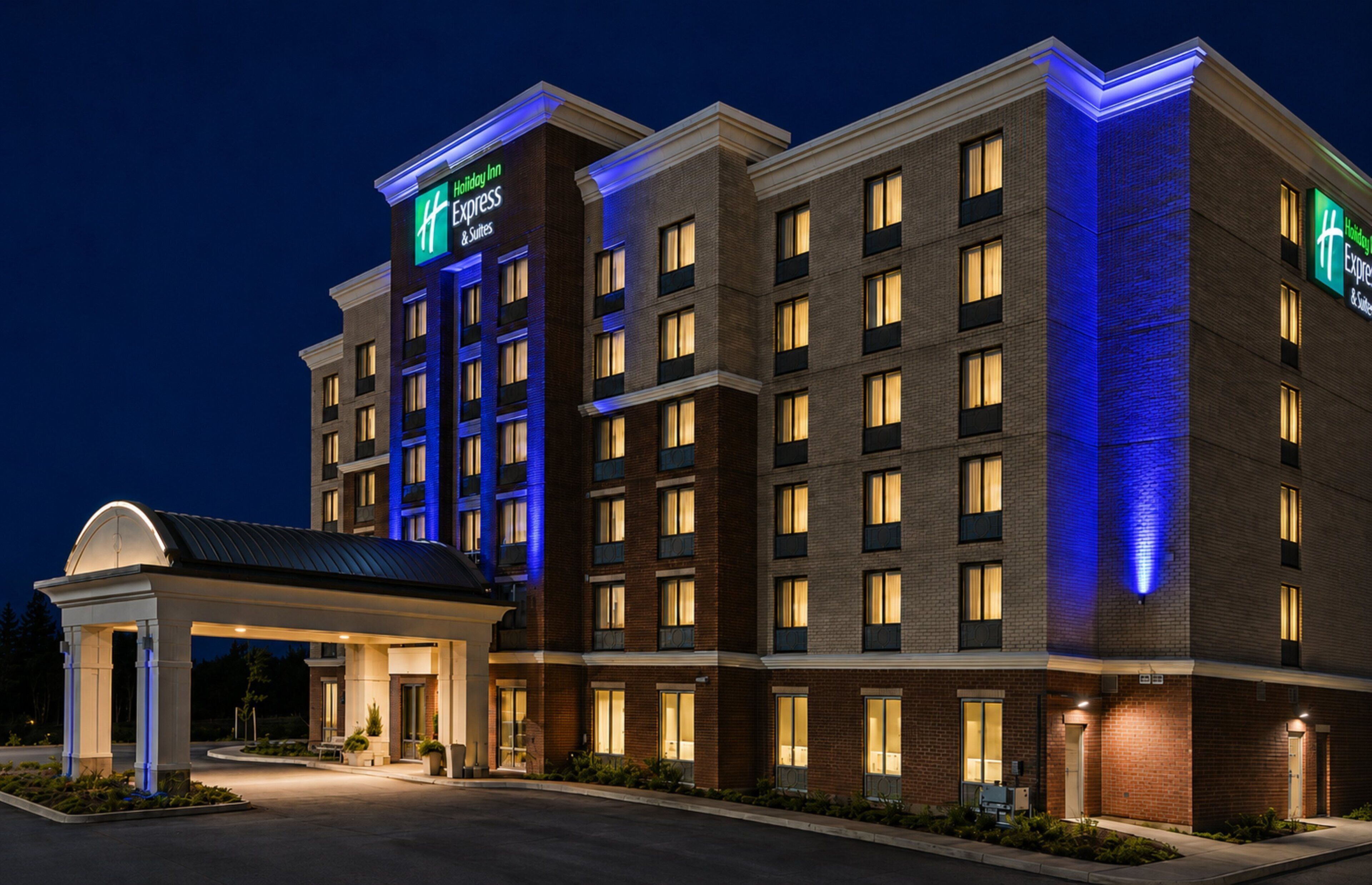 Um hotel Holiday Inn Express com design moderno, com vários andares e uma entrada bem iluminada.