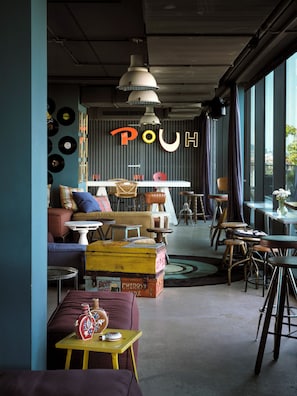 Um interior aconchegante com sofá, mesas e uma parede com discos de vinil.