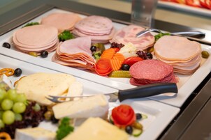 Buffet com diversos tipos de carne, queijos e legumes.
