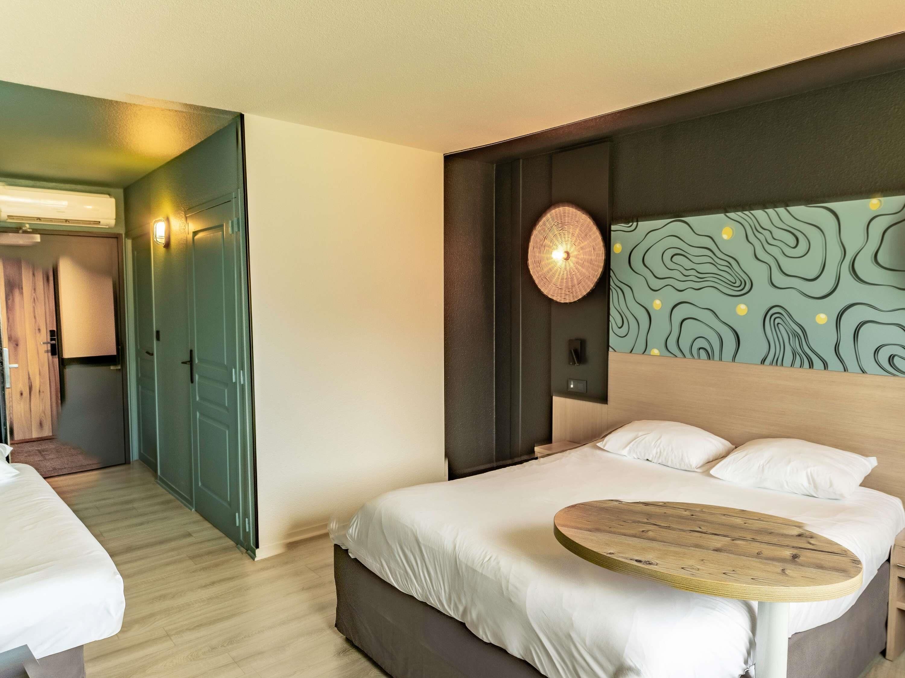 Quarto de hotel com cama, mesa de cabeceira e parede com design exclusivo.