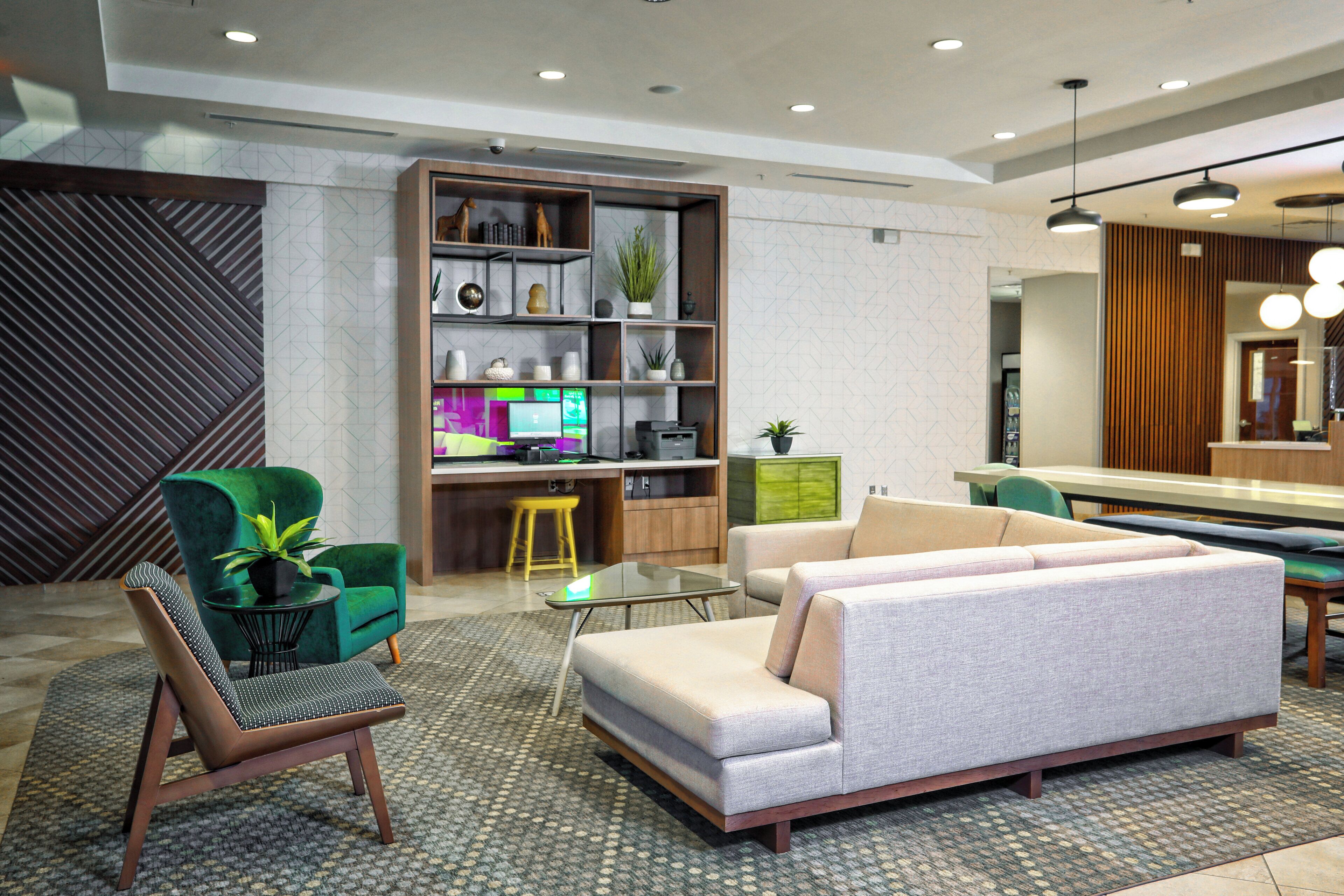 Uma área de estar moderna com sofá, poltronas, mesa de centro e estante de livros.