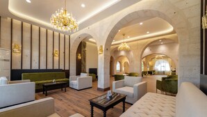 Um hall amplo com pé direito alto, portas em arco e luminárias modernas.