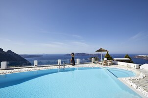 Piscina com vista clara para o mar e montanhas ao fundo.