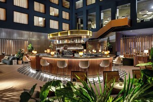Uma área de bar moderna com balcão curvo, banquetas e diversas opções de assentos.