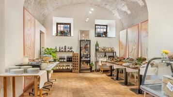 Um restaurante com chão de tijolos, mesas de madeira e diversas opções de comida e bebida.