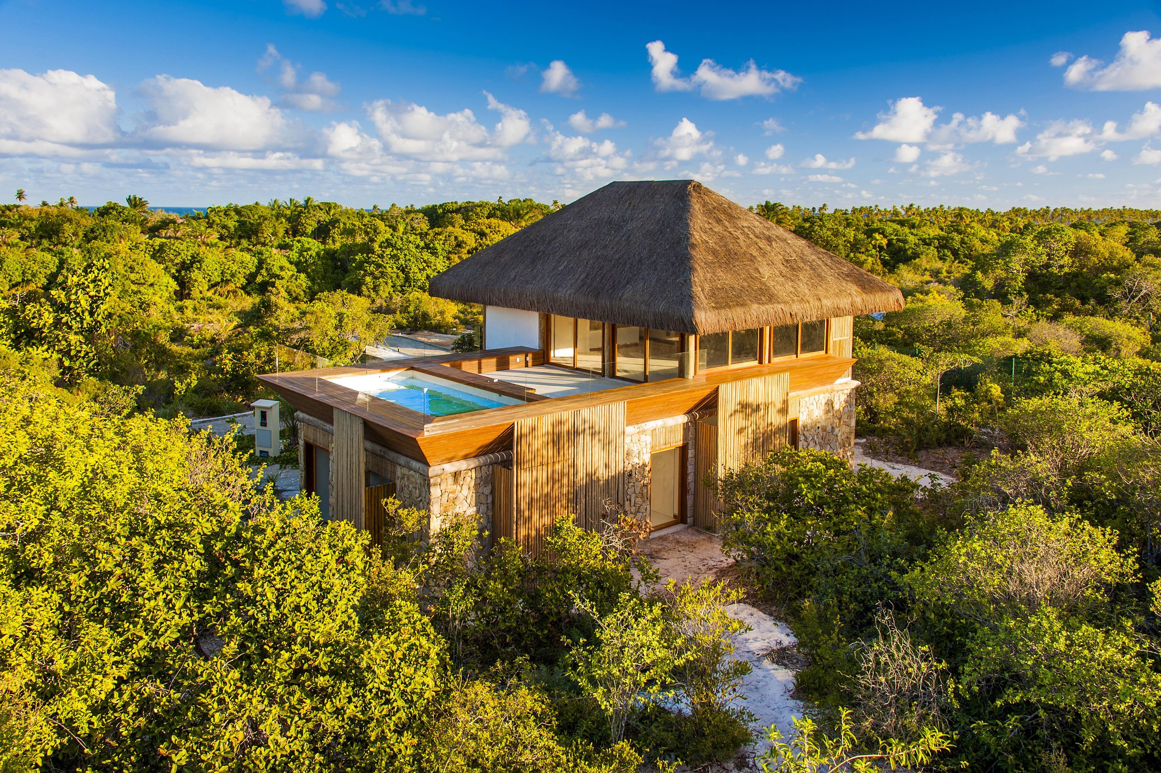 Uma villa moderna com piscina, rodeada por vegetação tropical exuberante.