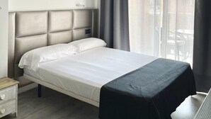 Quarto de hotel com cama, mesa de cabeceira e ar condicionado.