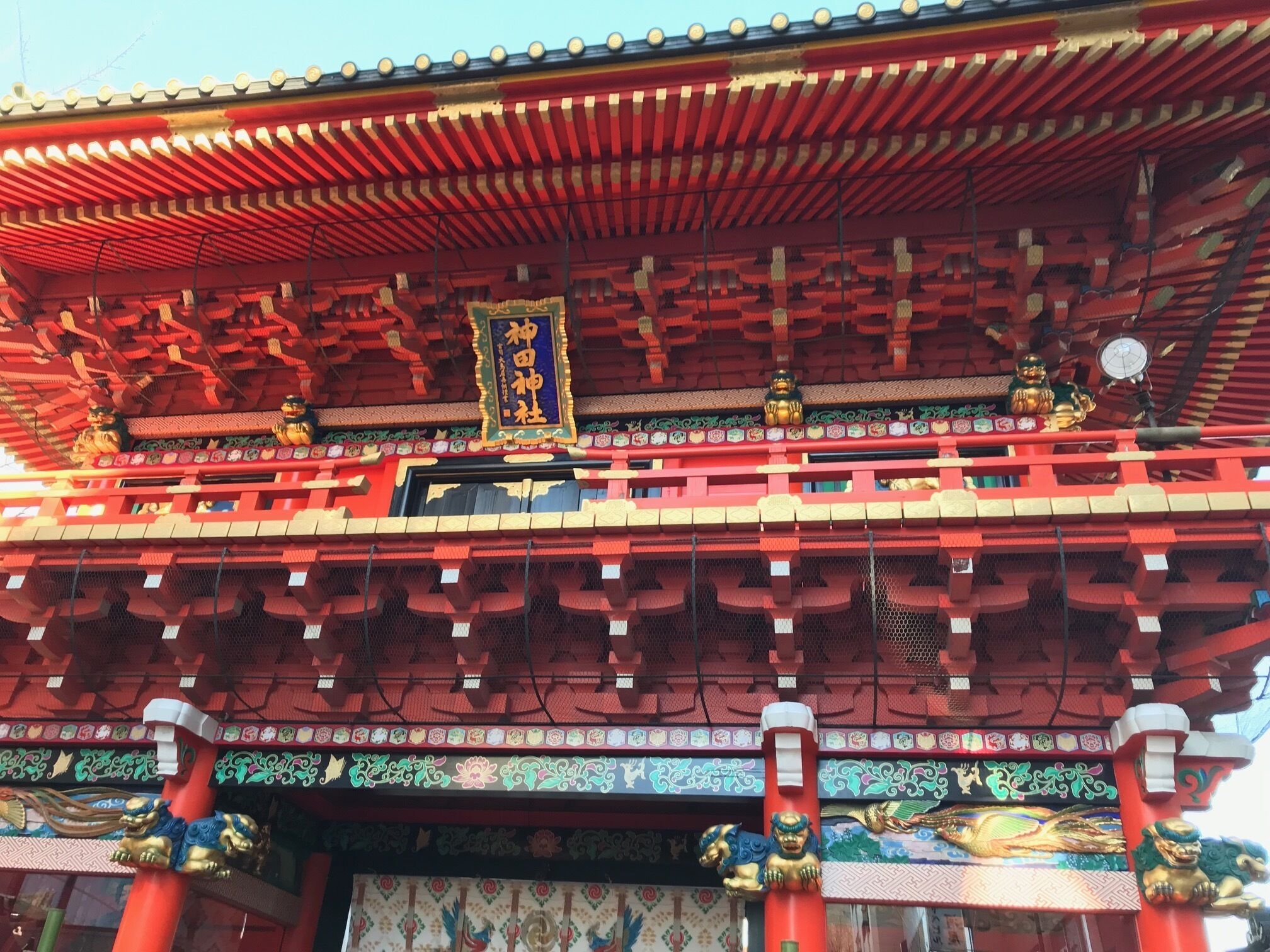 Um edifício tradicional nas cores vermelho e dourado, com desenhos detalhados e estátuas.