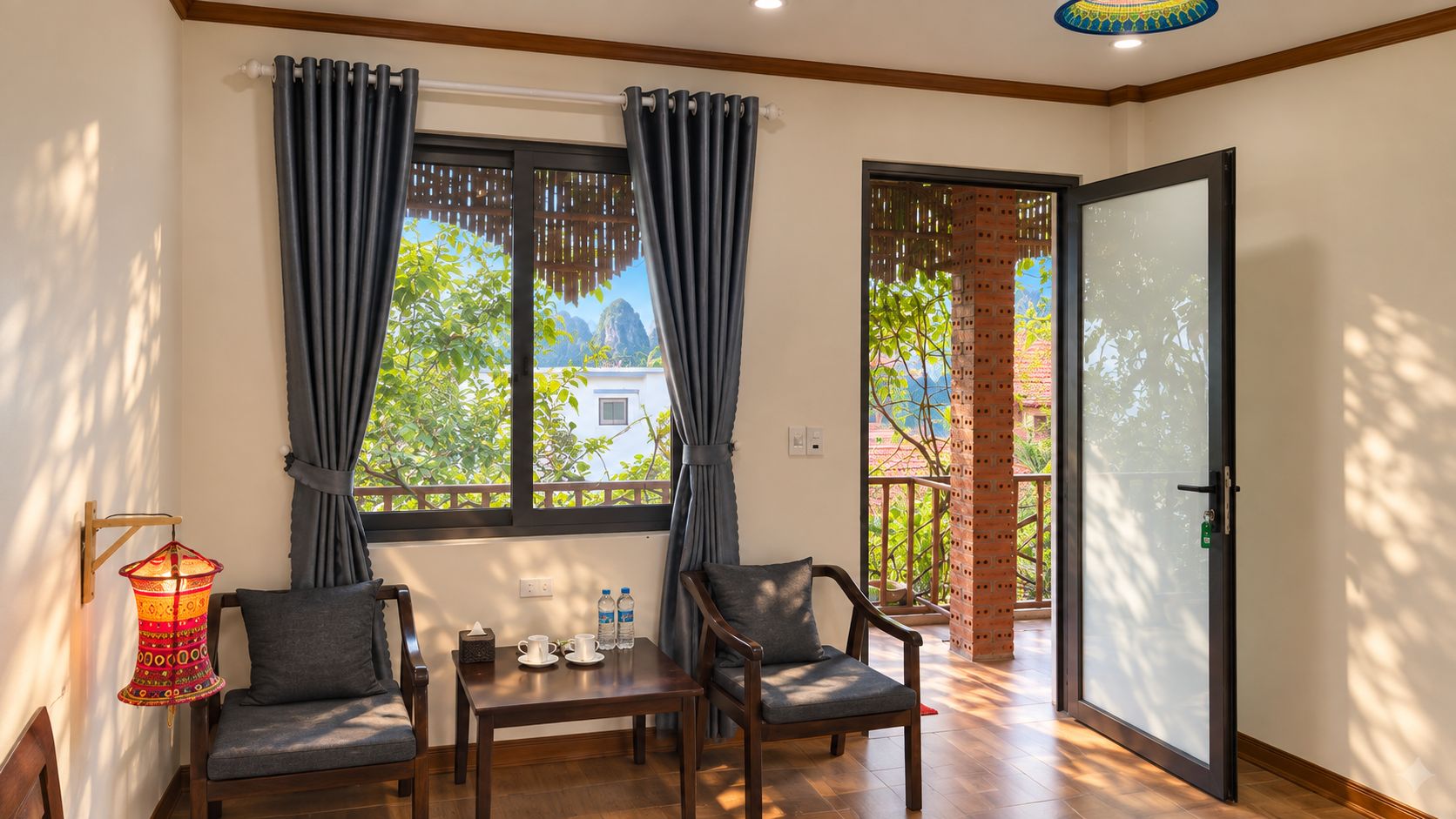 Quarto com uma mesa, duas cadeiras, janela com cortinas, porta e vista para área verde lá fora.