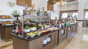 Buffet com diversos alimentos e uma placa indicando 'Buffet com serviço de catering'.