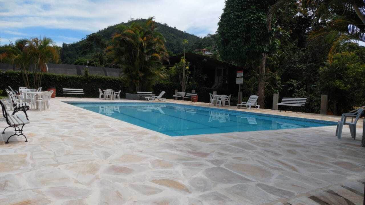 Piscina retangular com um deck de pedra ao redor.