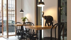 Uma sala de jantar com mesa de madeira, cadeiras pretas e iluminação pendente.