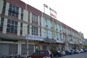 Um edifício de vários andares com placas indicando CK Hotel, OYO e Nostalgia Jaya Enterprise.