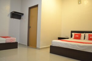 Quarto de hotel com cama, mesa de cabeceira, guarda-roupa e uma porta.