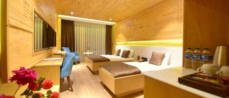 Quarto de hotel moderno com teto de madeira, escrivaninha com cadeira, cama com cabeceira e mesa de cabeceira.