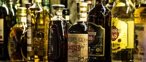 Diversas garrafas de bebidas alcoólicas numa estante.