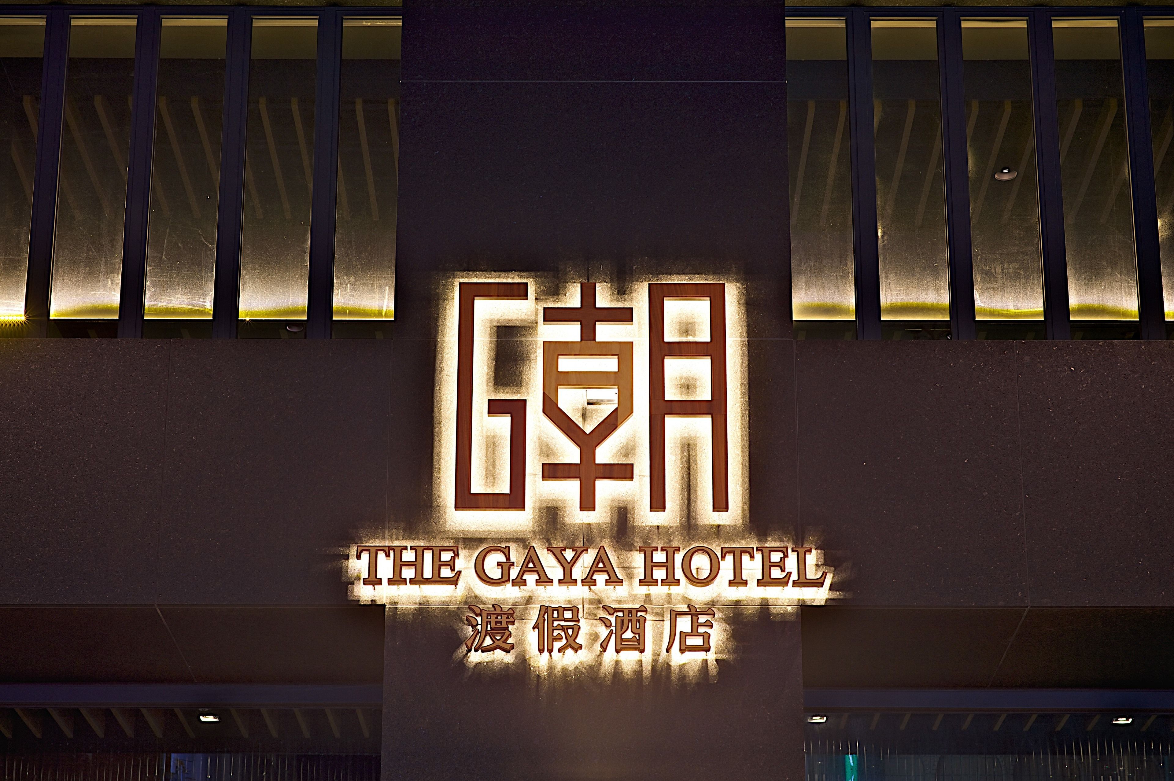 Placa do Hotel Gaya com letras iluminadas e nome em inglês e chinês.
