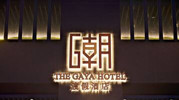Placa do Hotel Gaya com letras iluminadas e nome em inglês e chinês.