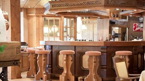 Uma área de bar com banquetas de madeira e balcão.