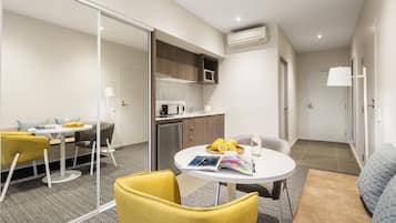 Um quarto moderno e bem iluminado, com área de refeições, cozinha e espaço para sentar.
