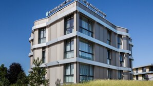 Um edifício moderno com a placa "VISIONAPARTMENTS" no topo.