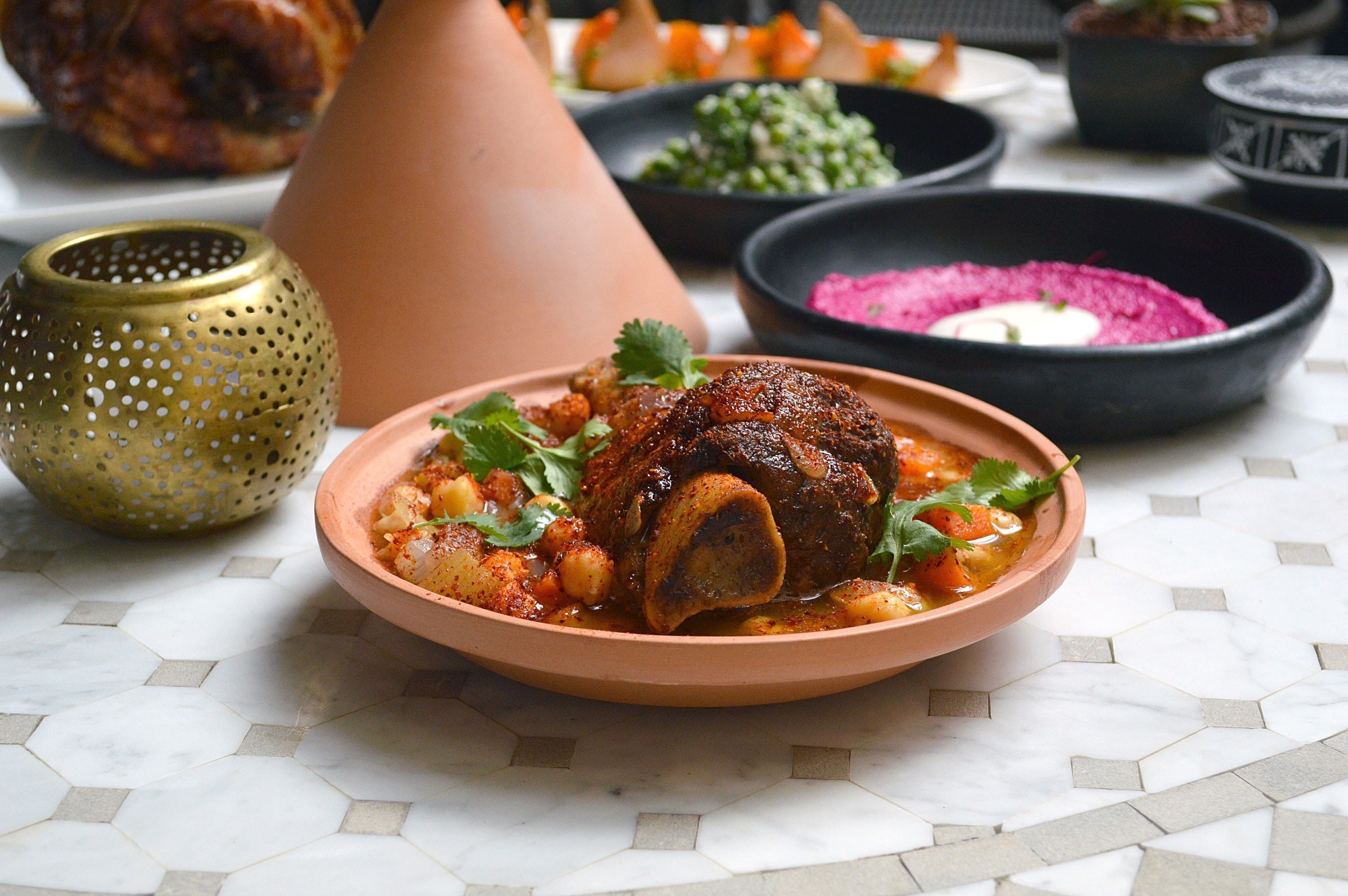 Um prato marroquino tradicional de tajine com carne e legumes, servido em um prato de barro.