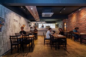 Um restaurante com paredes de tijolo, mesas e cadeiras de madeira.