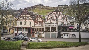 Um edifício tradicional em estilo de enxaimel numa vila, com uma placa a indicar "REILER-HOF".