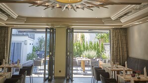 Restaurante com interior moderno, destacando um design de teto singular e vista para o exterior.