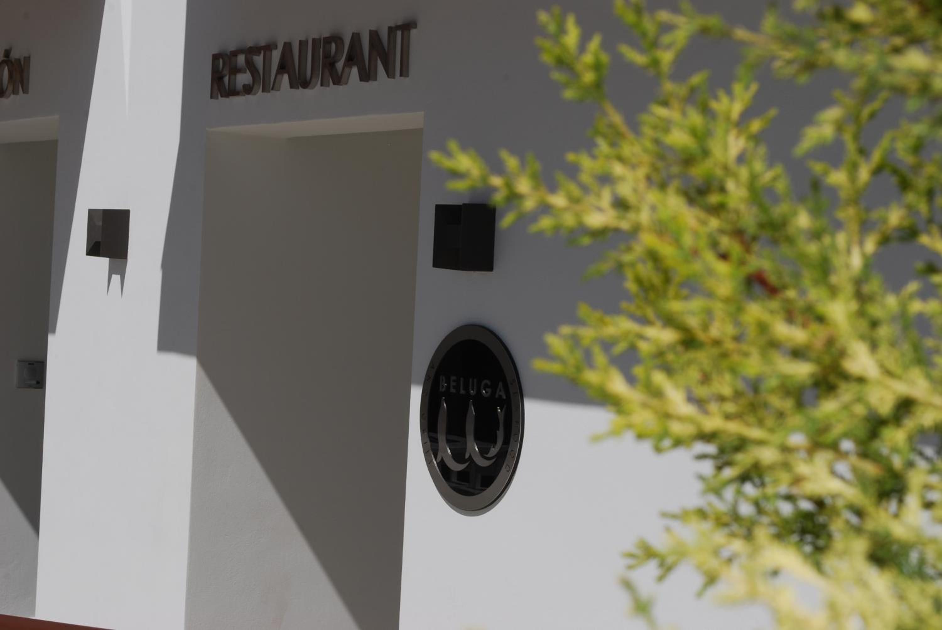 Fachada de um edifício com um letreiro que diz 'RESTAURANT' e um logotipo circular com o texto 'BELLUGA'.