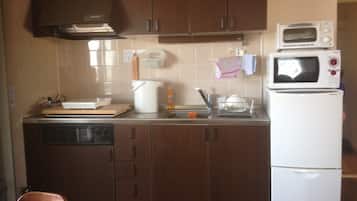 Um frigorífico/congelador grande, um micro-ondas, uma placa de cozinha