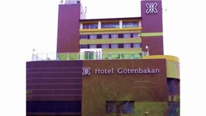 Hotel Gotenbakan com design arquitetônico moderno, destacando uma entrada imponente e uma placa com o nome do hotel.