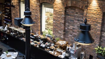 Um restaurante com parede de tijolos, luminárias pendentes e diversos alimentos e bebidas expostos no balcão.